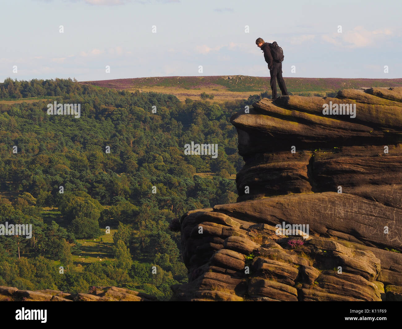 Hiker overlooking a cliff edge Stock Photo - Alamy