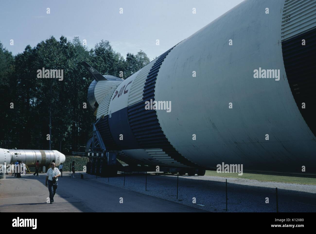 Man walking beside the fuselage of a giant rocket booster, the shadow ...