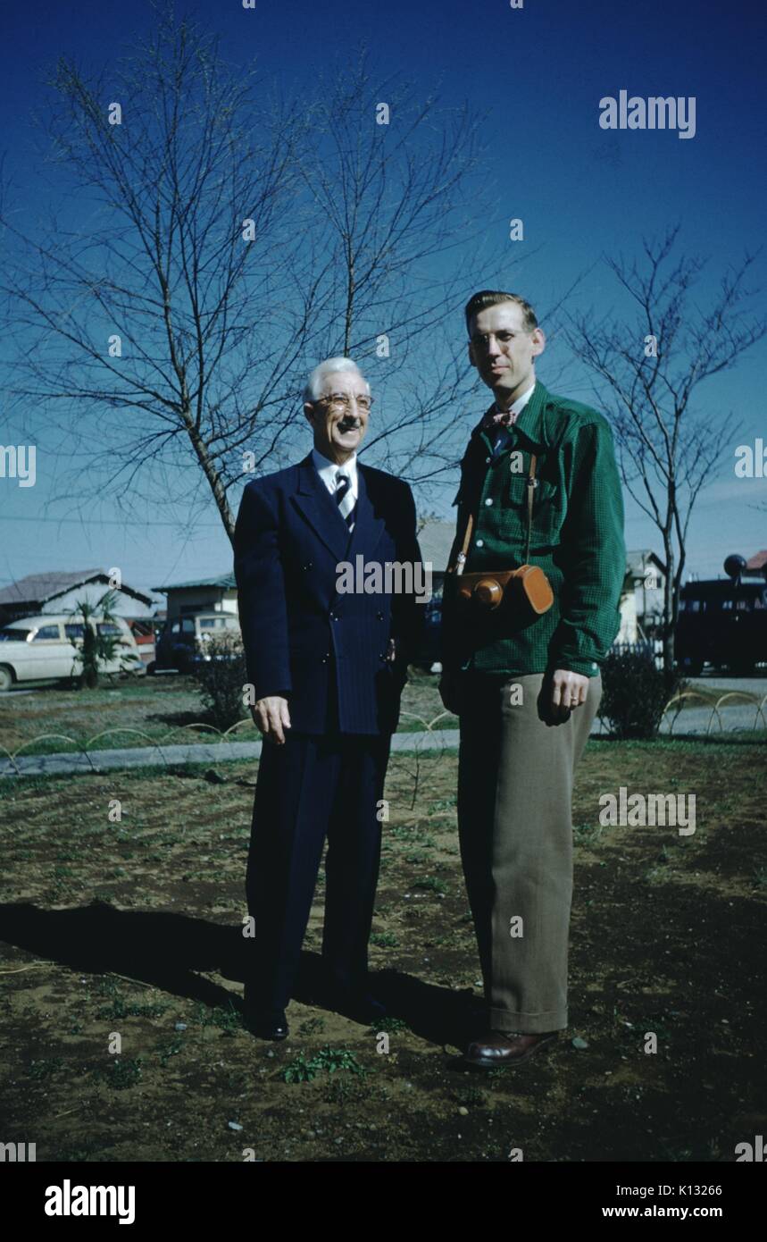 Missionary and father standing on the front lawn of a house, the ...