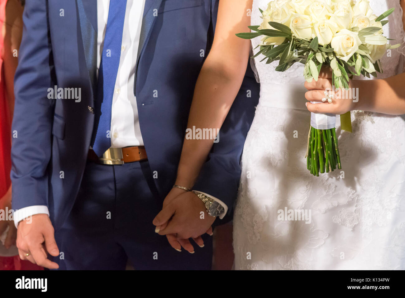 young wedding couple holding their hands in ceremony Stock Photo - Alamy