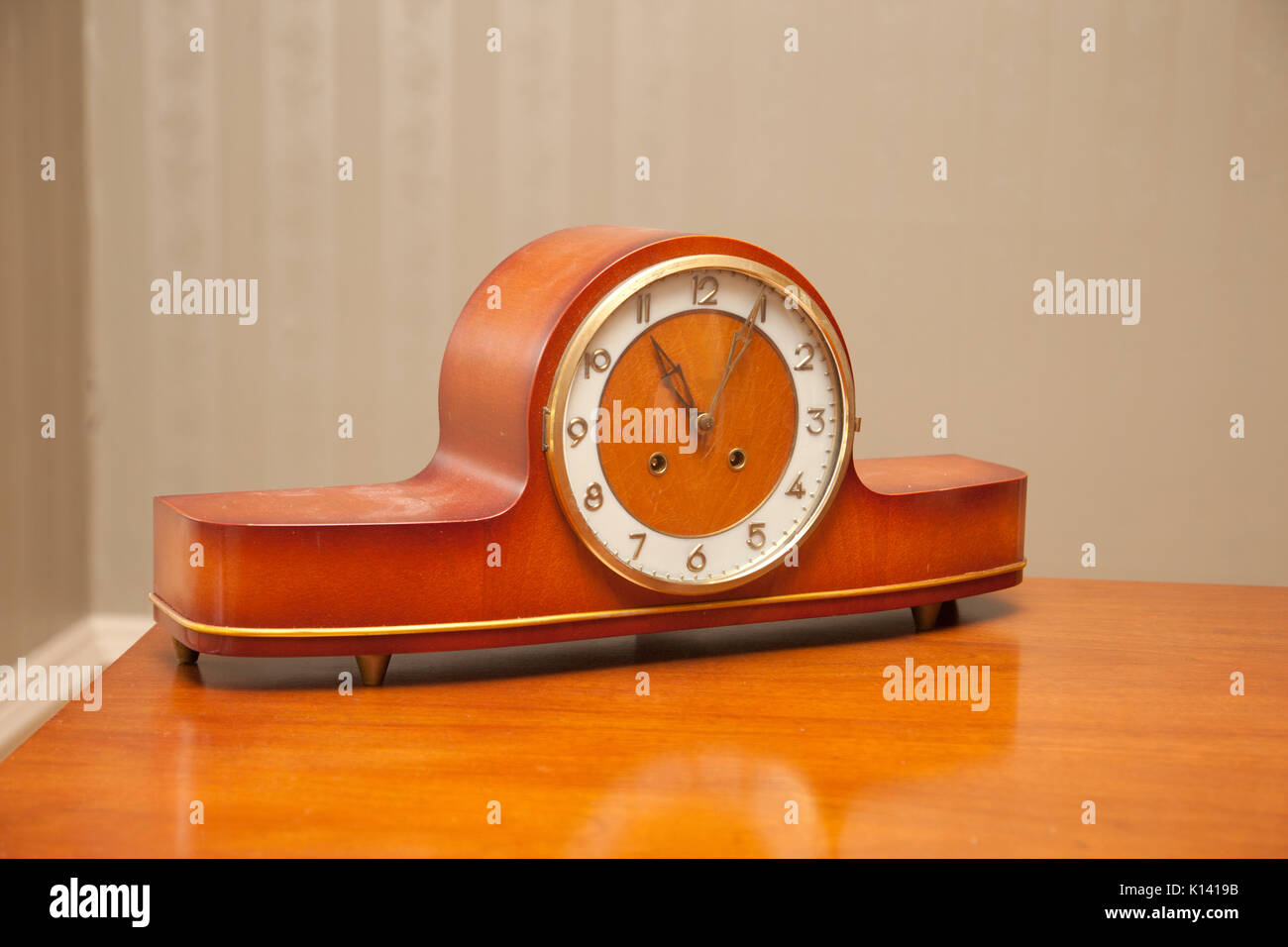 a wooden antique or vintage clock with round edges and brass hands ...