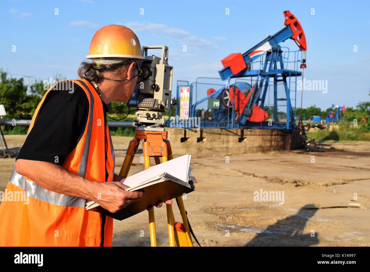 Surveyor at work and crude oil pump in background Stock Photo - Alamy