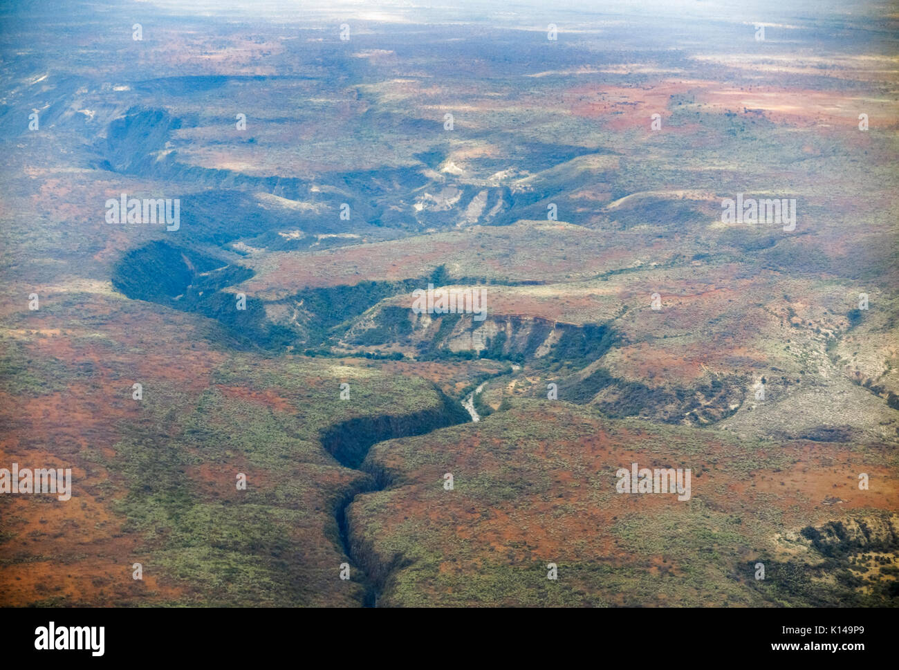 Aerial view of landscape on the Masai Mara, Kenya with deep ravines cut ...
