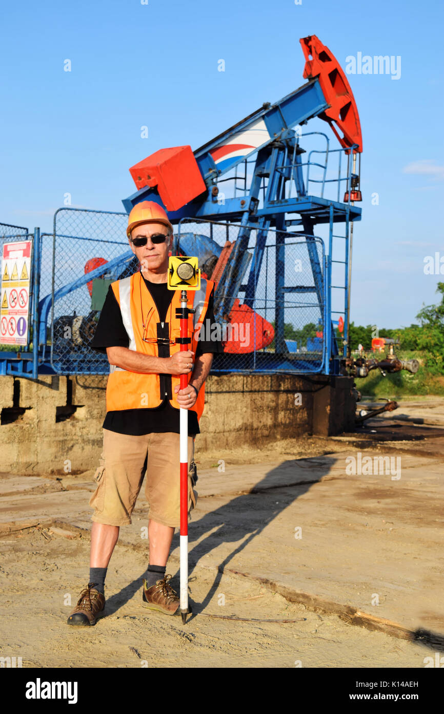 Surveyor at work and crude oil pump in background Stock Photo - Alamy