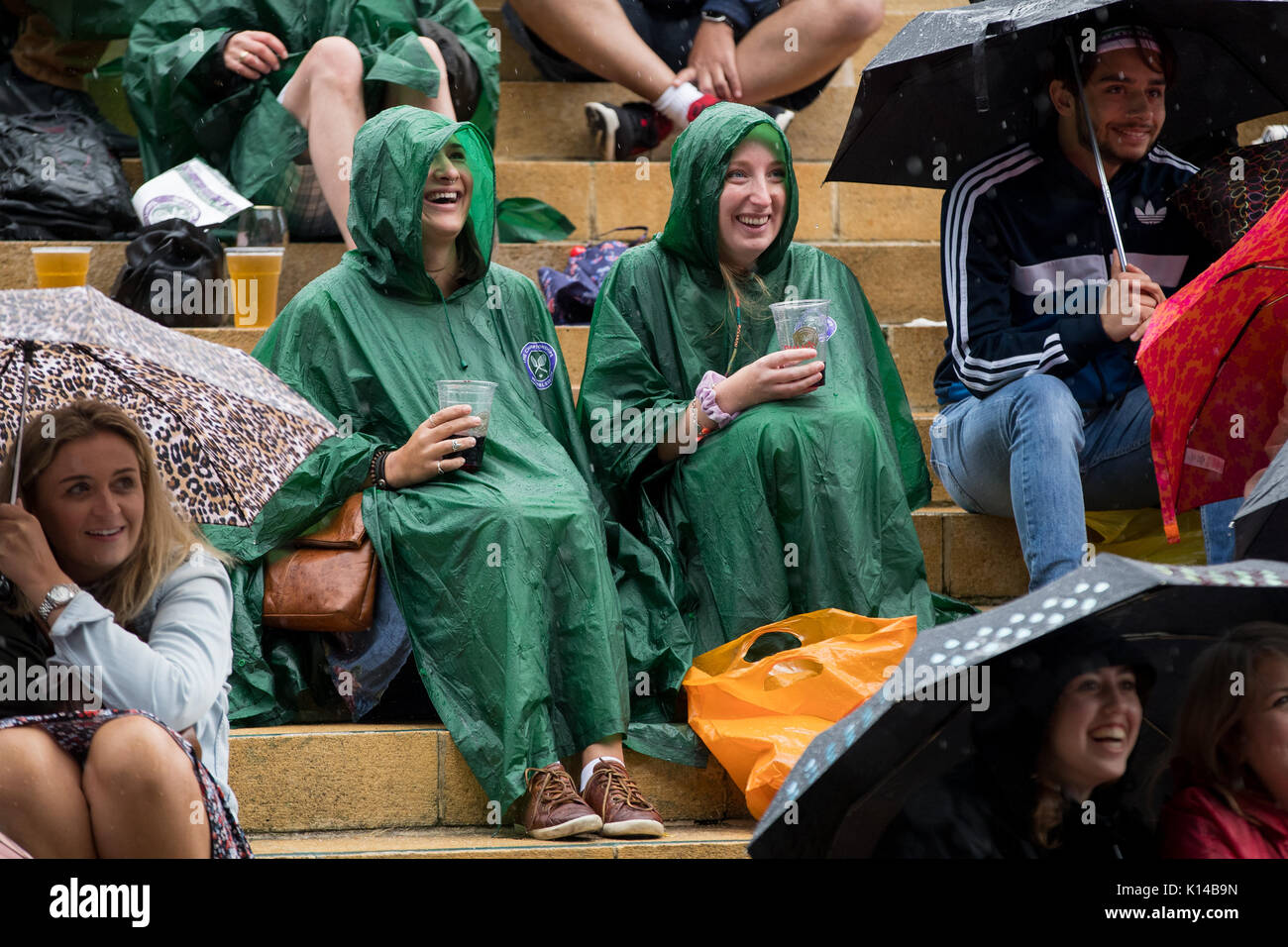 Fans watch the big screen by Henman Hill in the rain at the Wimbledon ...
