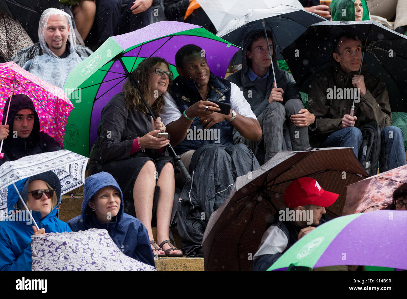 Fans watch the big screen by Henman Hill in the rain at the Wimbledon ...