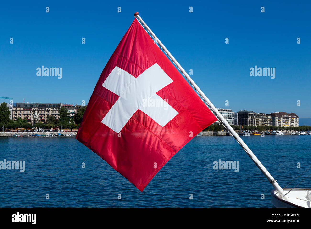 The Swiss flag, flag of Switzerland, flying over Lake Geneva / Lac ...