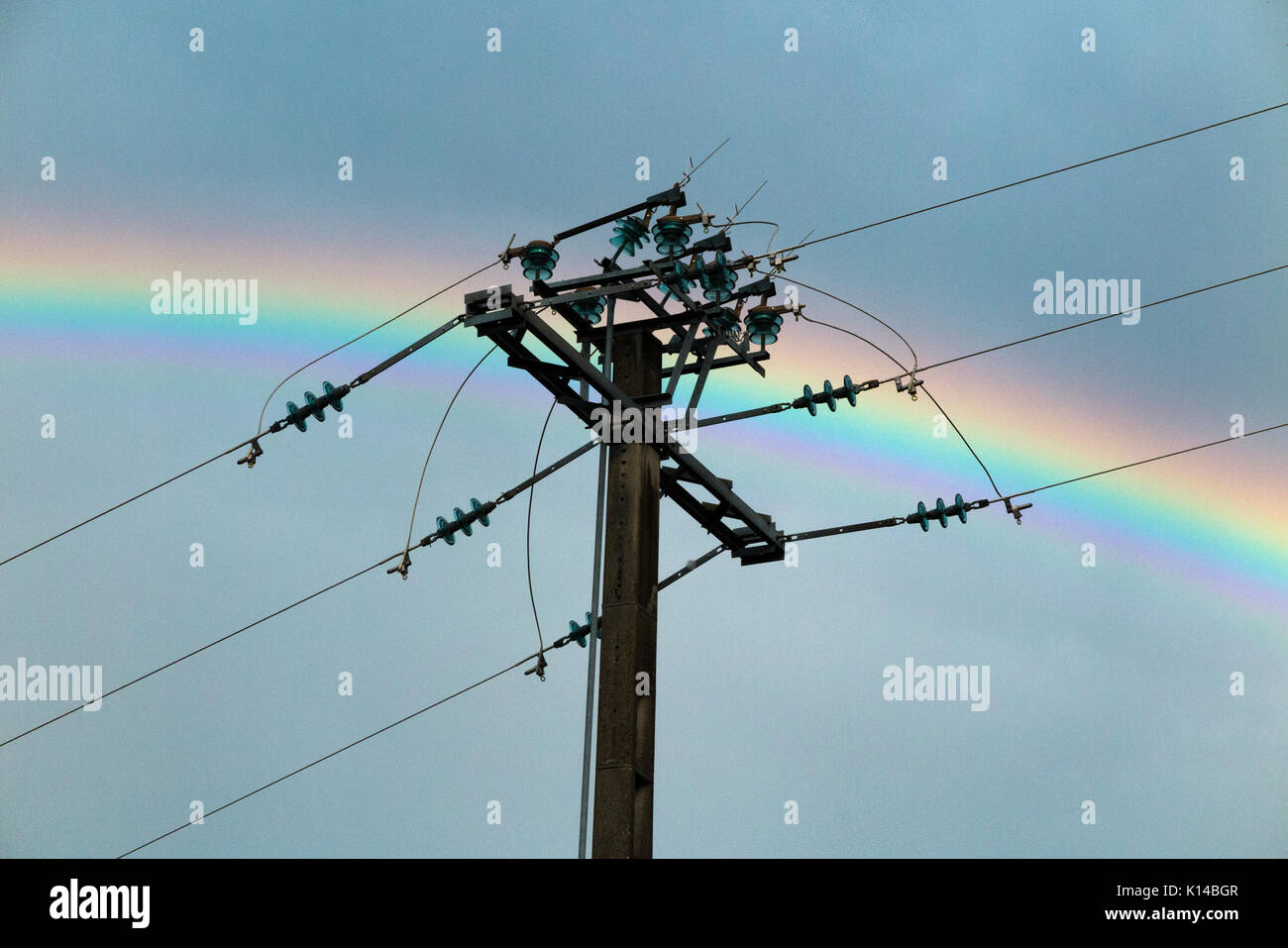 Rainbow behind electricity transmission wires and pylon to the show and ...