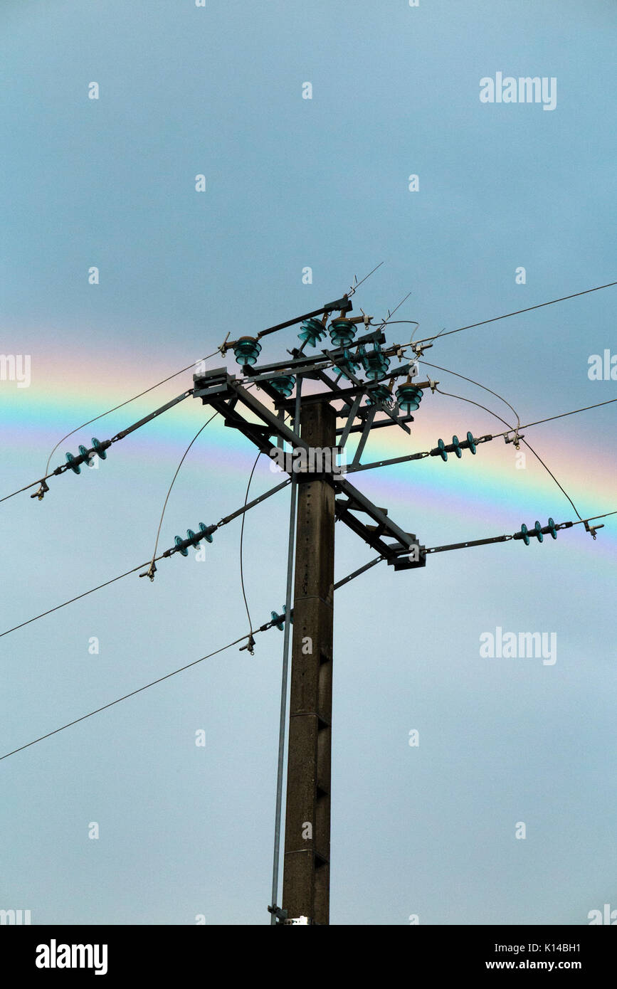 Rainbow behind electricity transmission wires and pylon to the show and ...