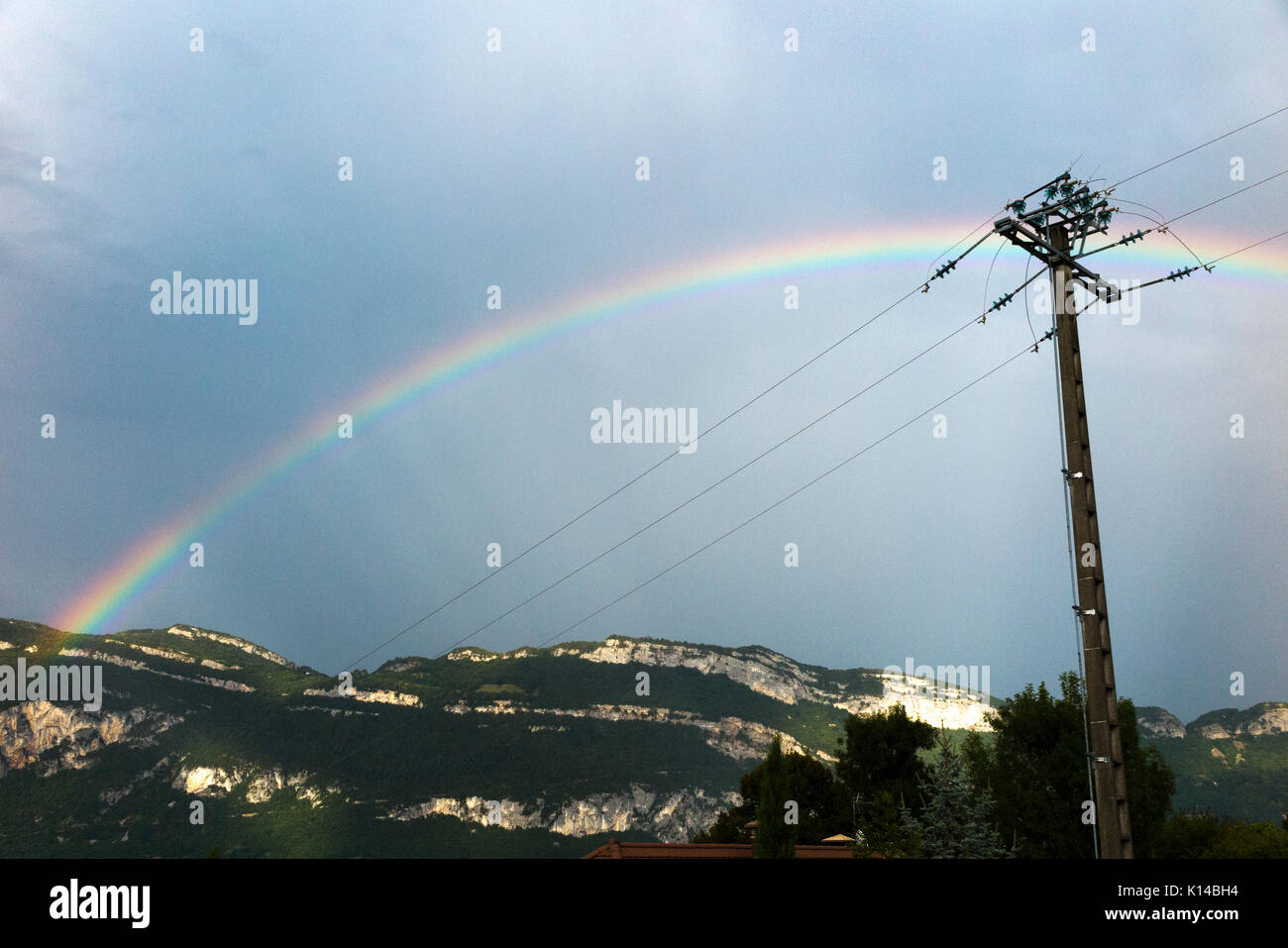 Rainbow behind electricity transmission wires and pylon to the show and ...
