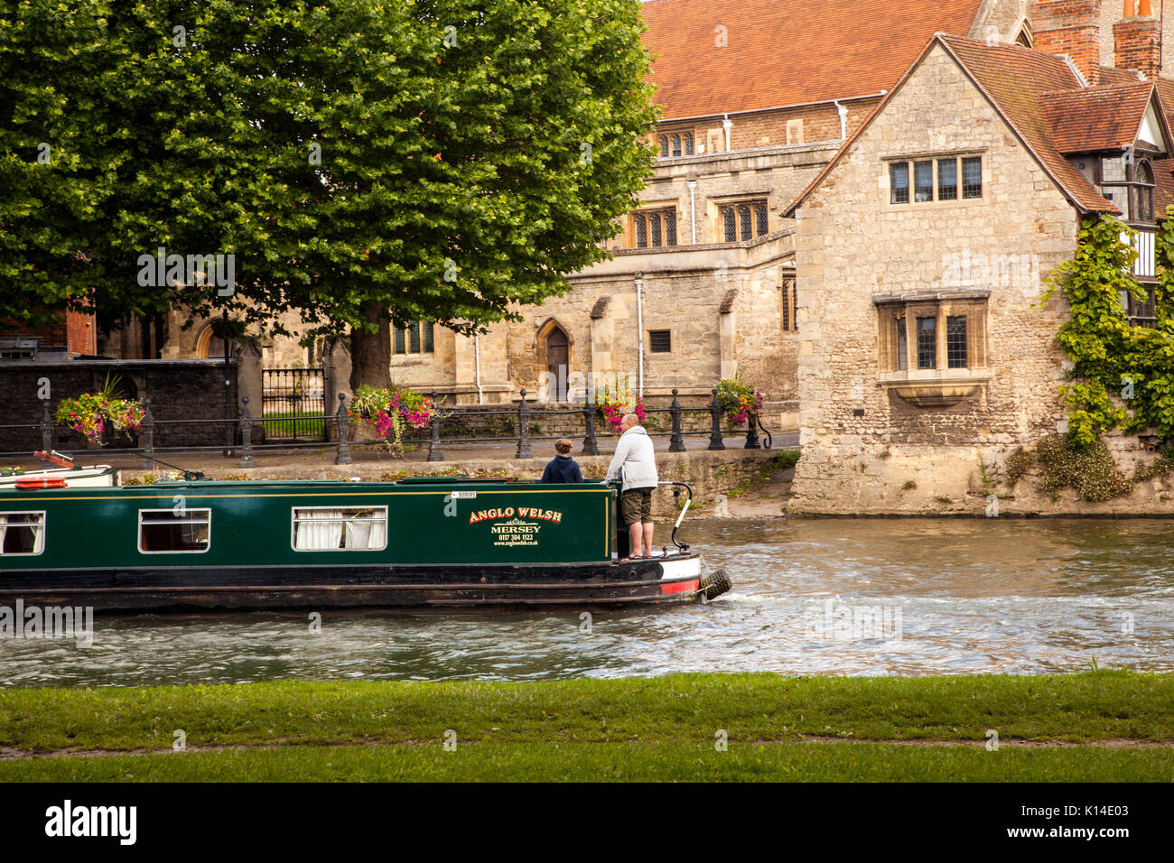 Canal narrowboat on the river Thames passing St Helen's church and St ...