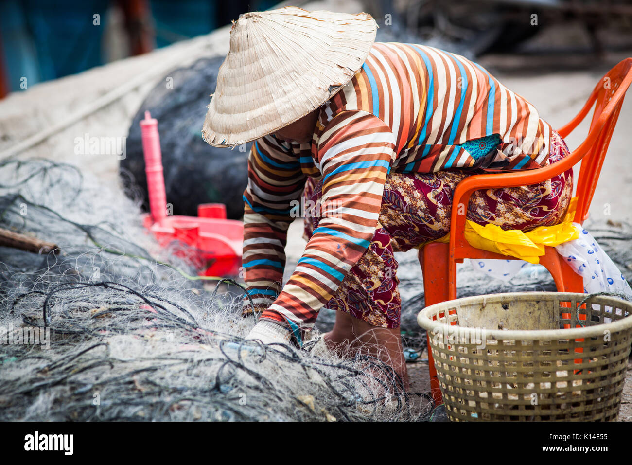 vietnamese woman repairing fishing net Stock Photo - Alamy