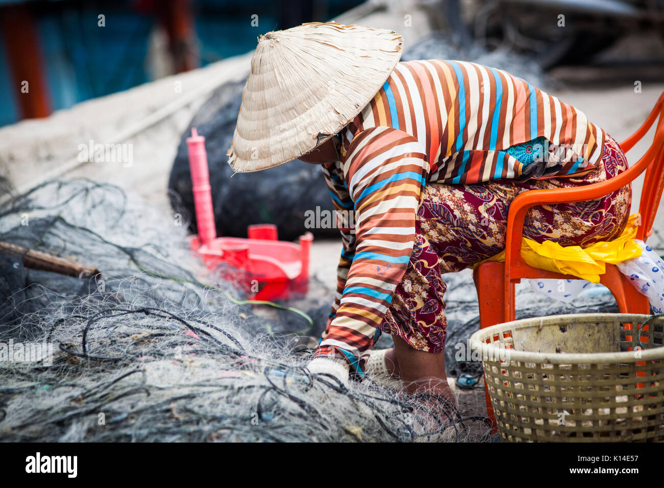 vietnamese woman repairing fishing net Stock Photo - Alamy