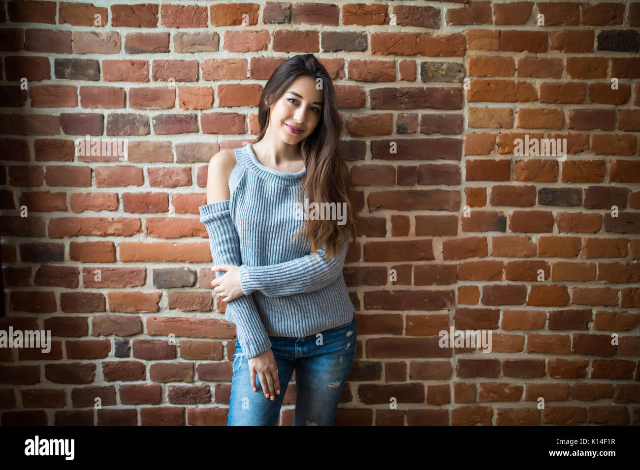 casual ginger girl standing against brick wall Stock Photo - Alamy