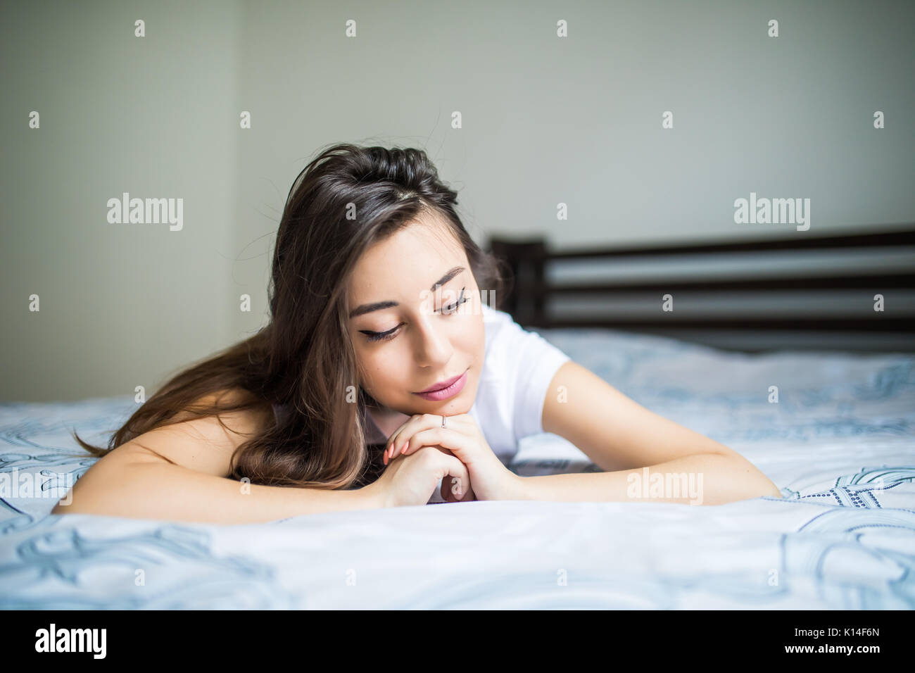 A woman lying on the bed and smiling Stock Photo - Alamy