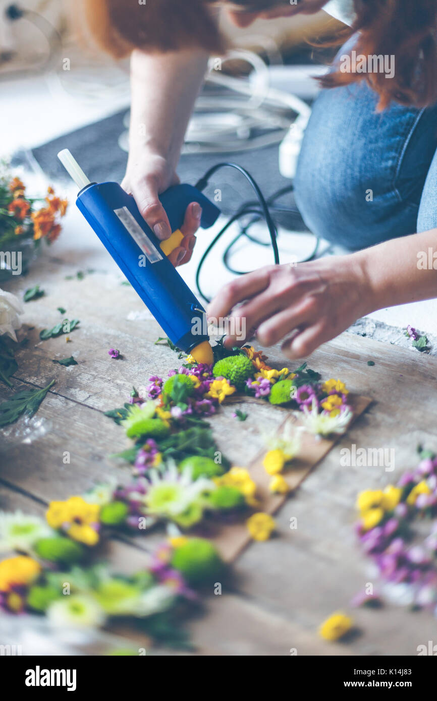 Florist making flower decoration with letters and glue. Indoors natural ...