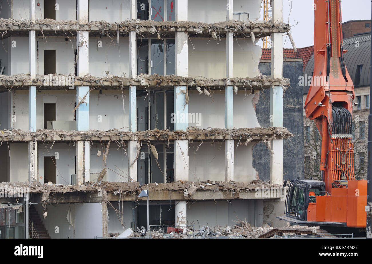 Close-up of demolished office building with missing wall and crane ...