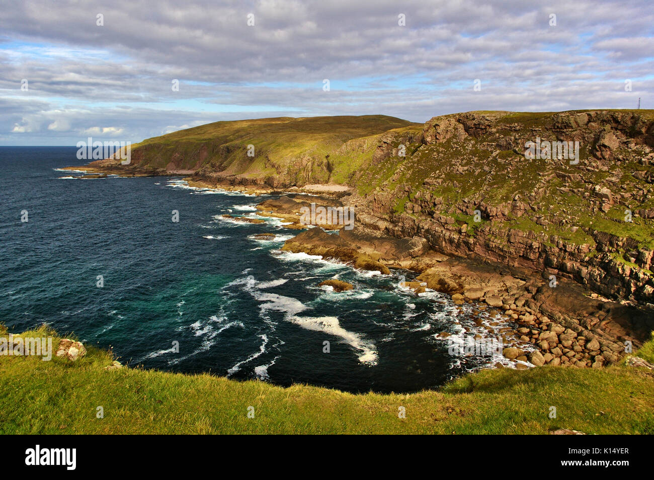 Rocky seashore on the Scottish west coast with steep cliffs, waves, sky ...