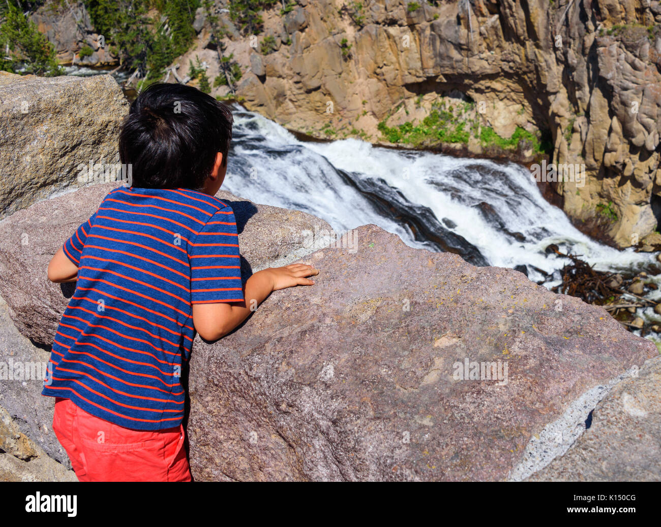 Back view of a kid, boy watching waterfall Stock Photo - Alamy