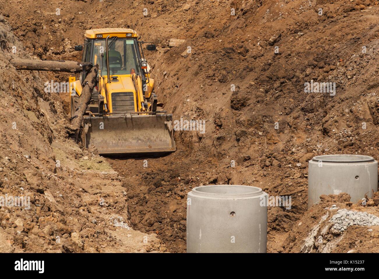 Construction of a new sewerage system. The bulldozer digs a trench for ...