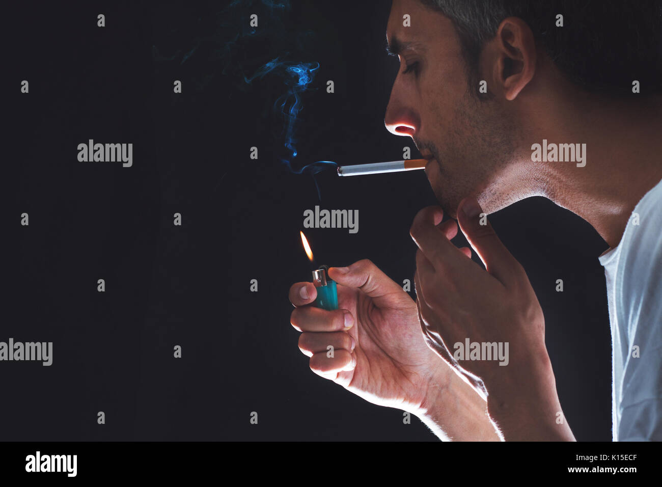 Young man lighting cigarette hi-res stock photography and images - Alamy