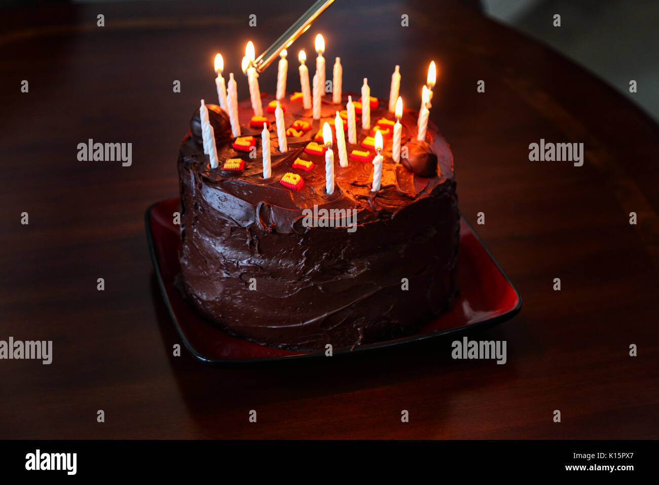 Lighting the candles of a birthday cake Stock Photo - Alamy