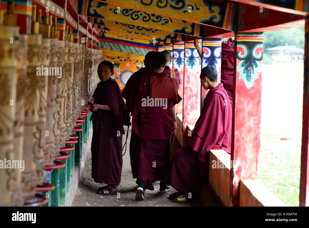 Buddhist monk children talking at the prayer wheels before class. Taken ...