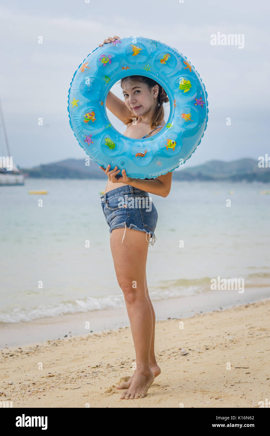 beautiful girl in bikini having fun on a tropical beach with rubber ...
