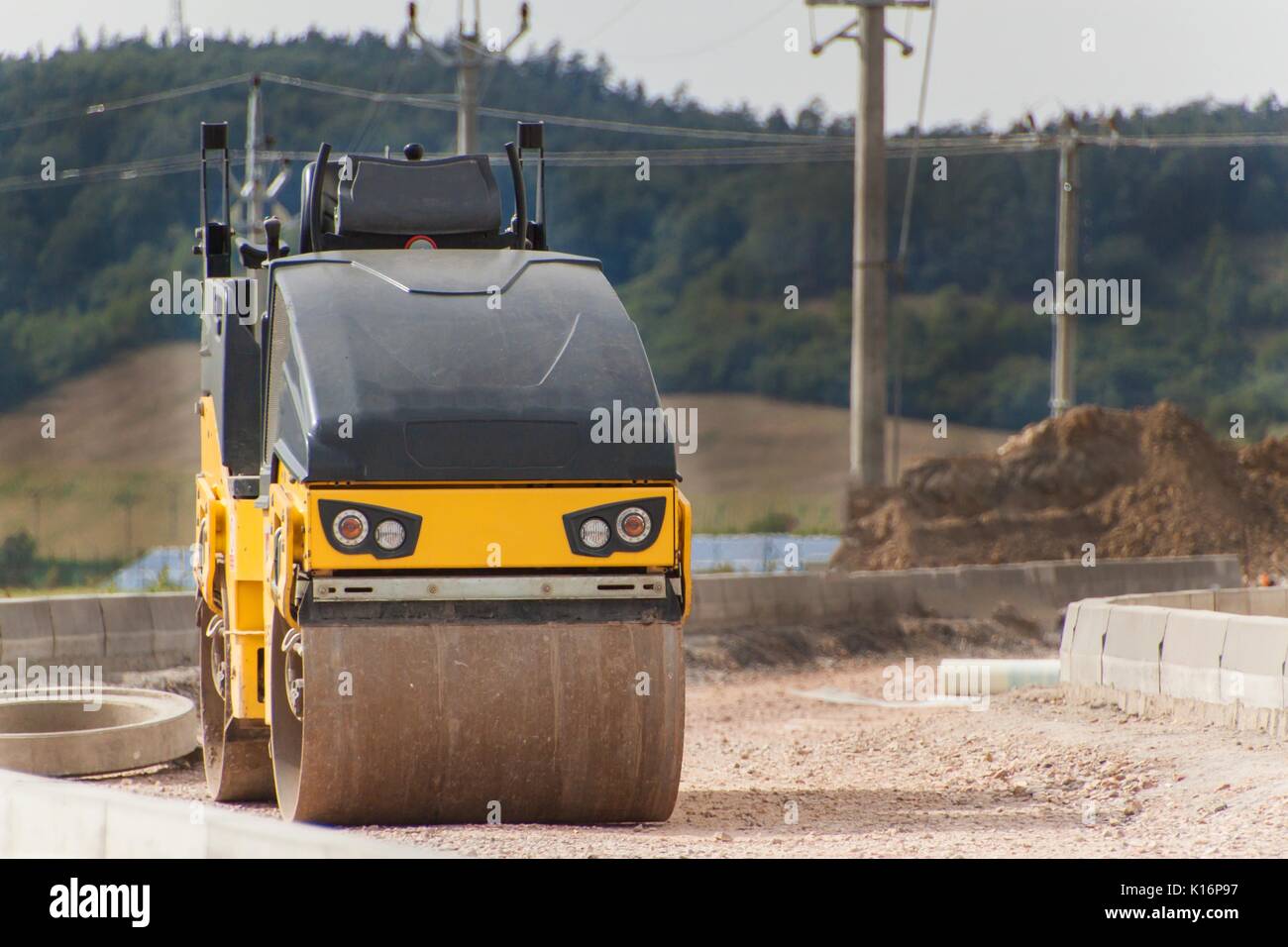 Road roller working on the new road construction site. Construction ...