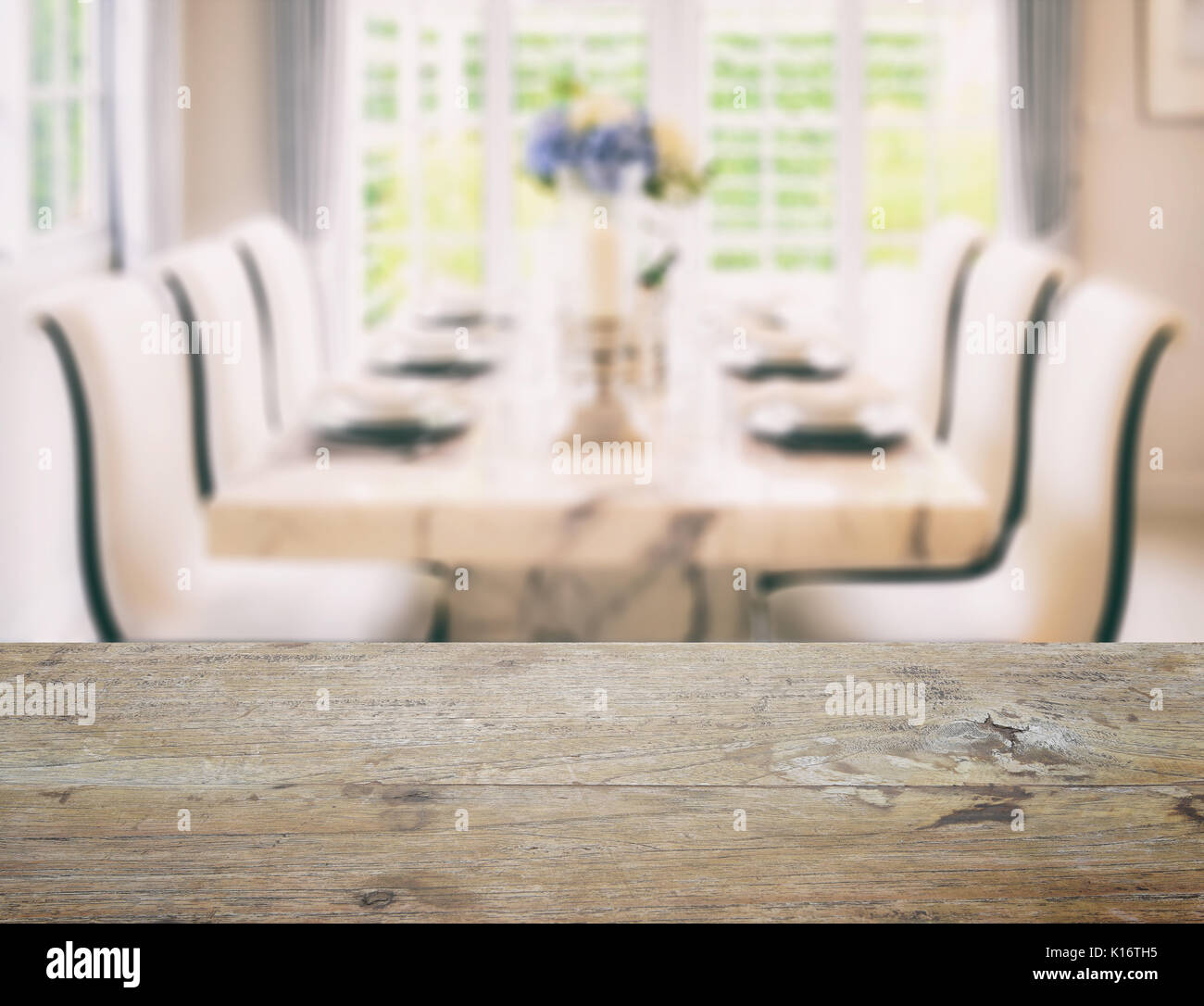 wooden table top with blur of dining table and comfortable chairs in ...