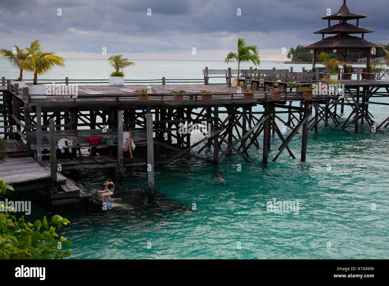 People snorkeling at Mabul Water Bungalows dive resort on Mabul Island ...