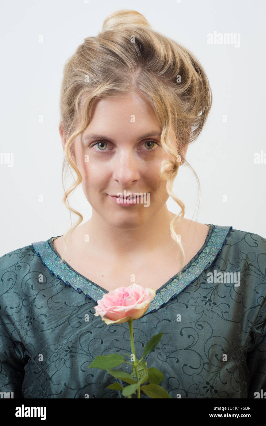 Beautiful blonde regency young woman holding a rose Stock Photo - Alamy