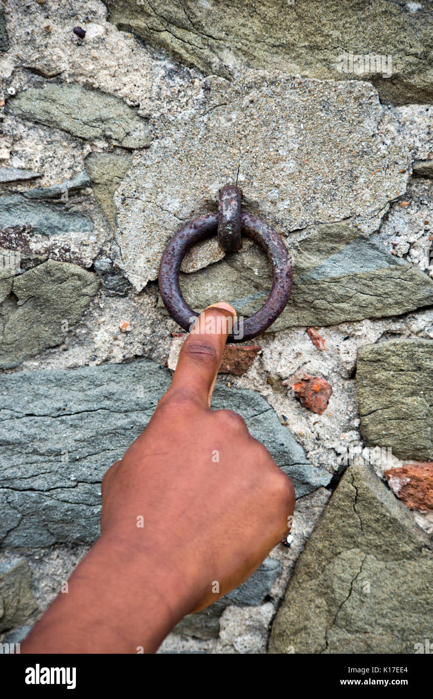 finger pulls an old rusty iron ring that acts as the bell of the old ...