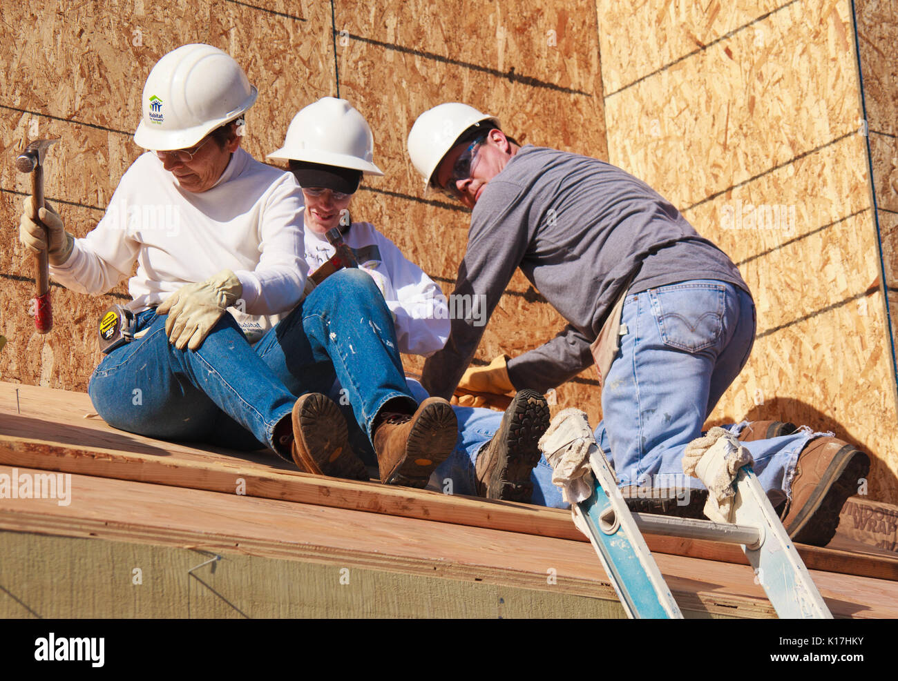Three people build roof for home for Habitat For Humanity For Humanity ...