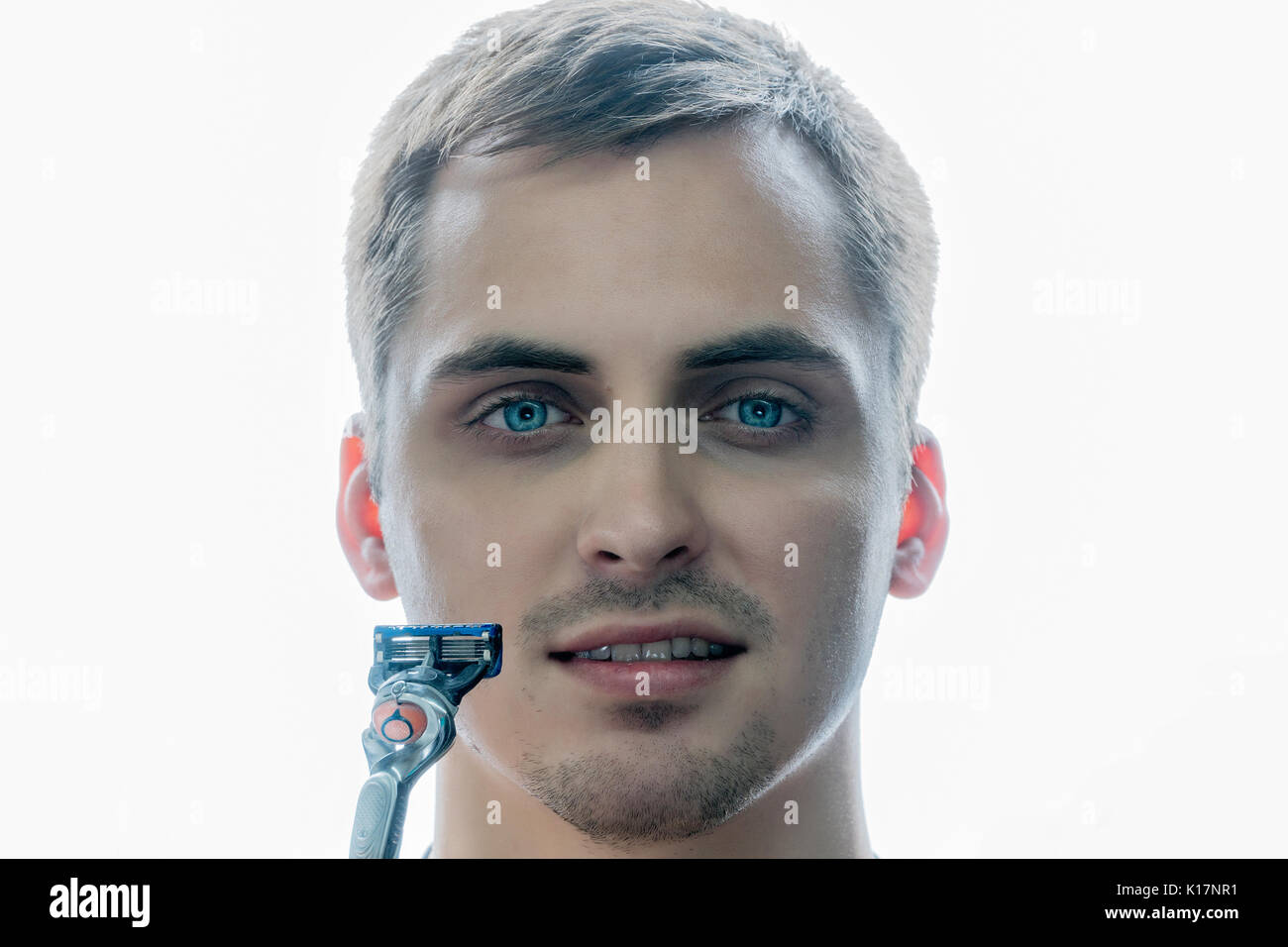 A happy guy with a razor in his hands. The guy is going to shave off ...