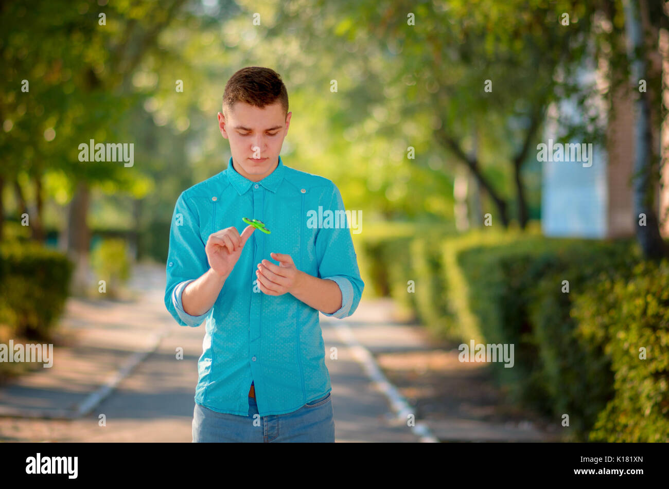 Nifty teenager holds one finger modern gadget fidget spinner. Man on ...