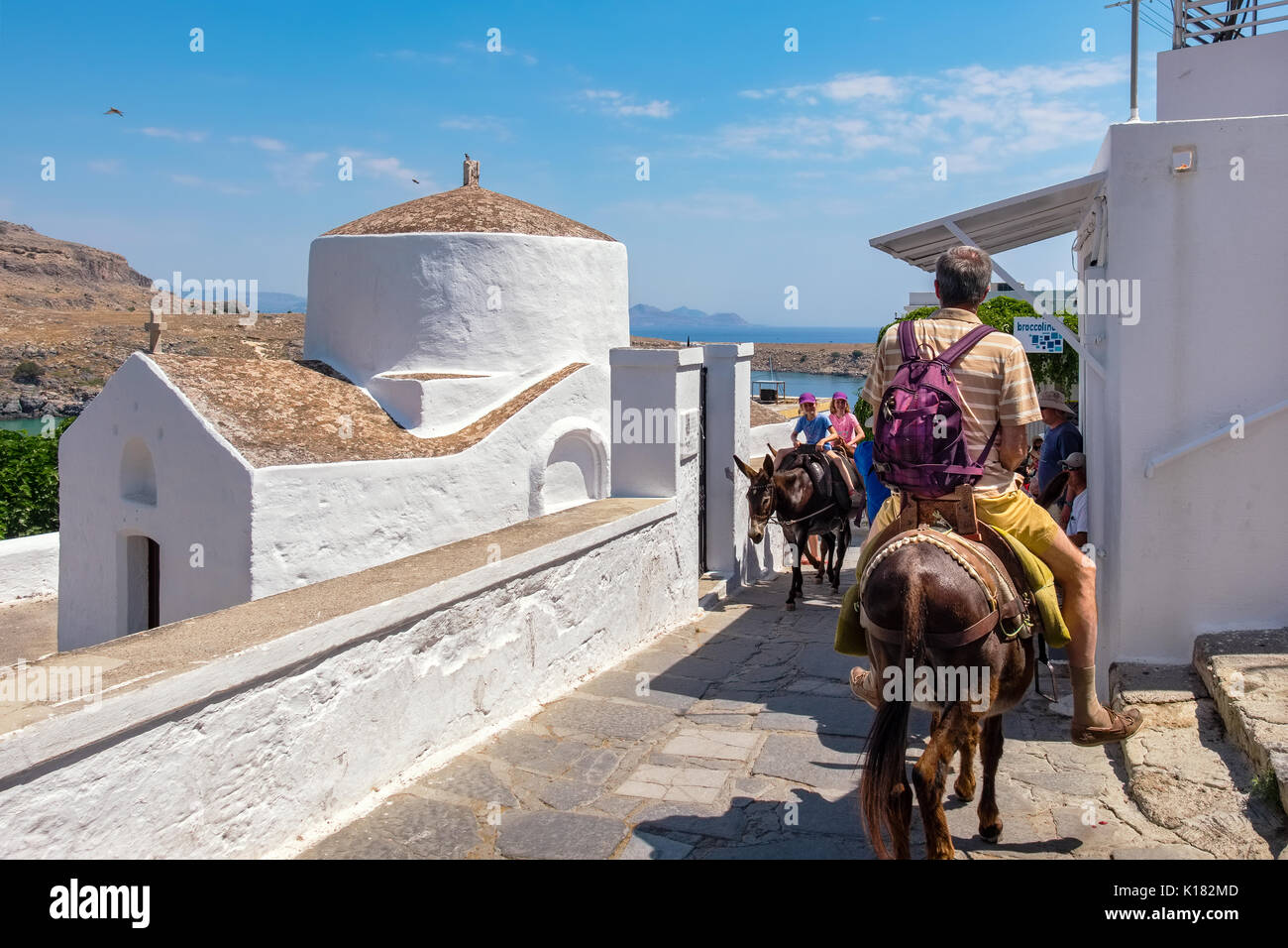 Tourists riding a donkeys past the chapel of Saint George Pahimahiotis ...
