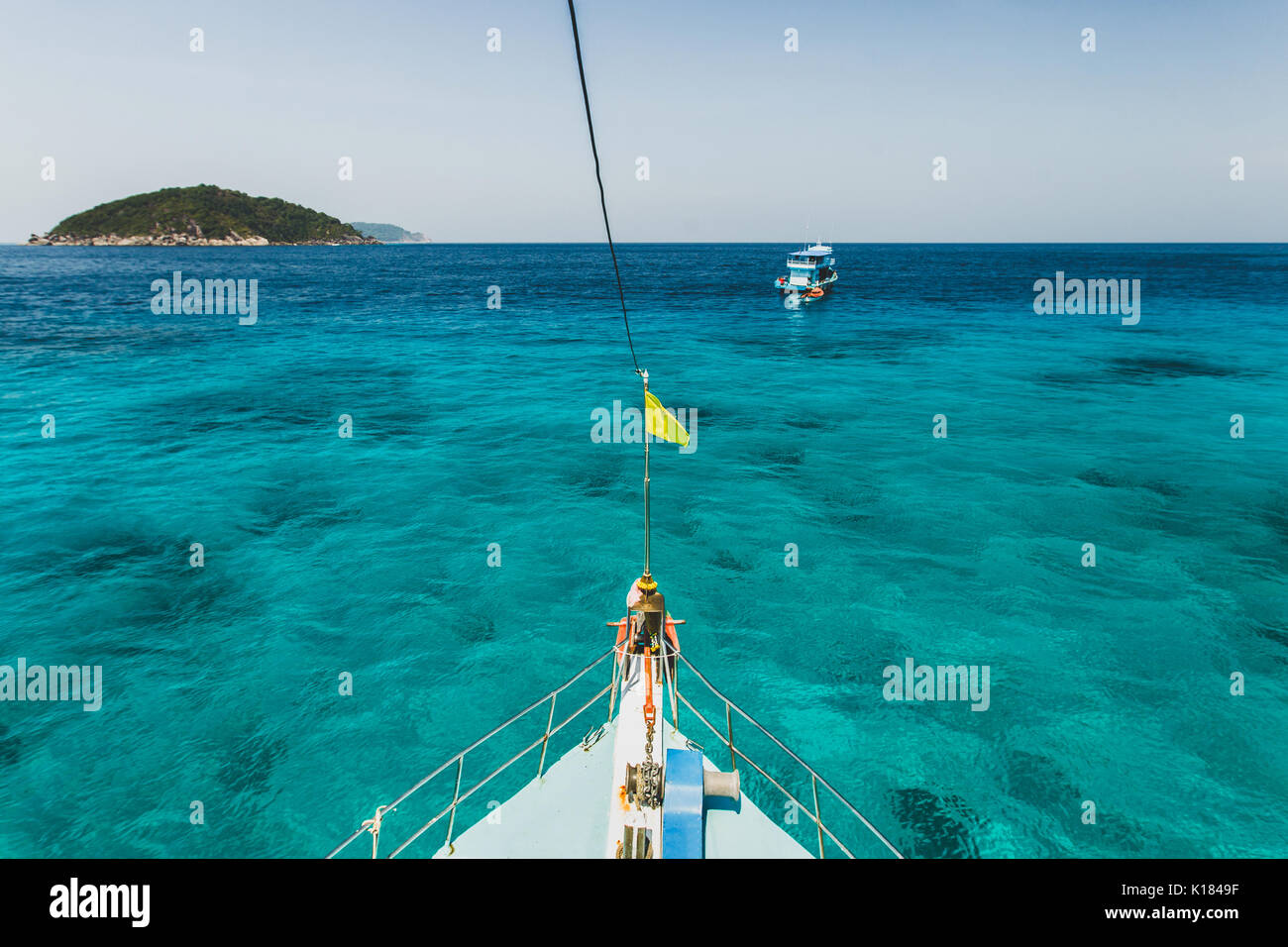 Tourist boat near island shore with turquoise clear transparent water ...