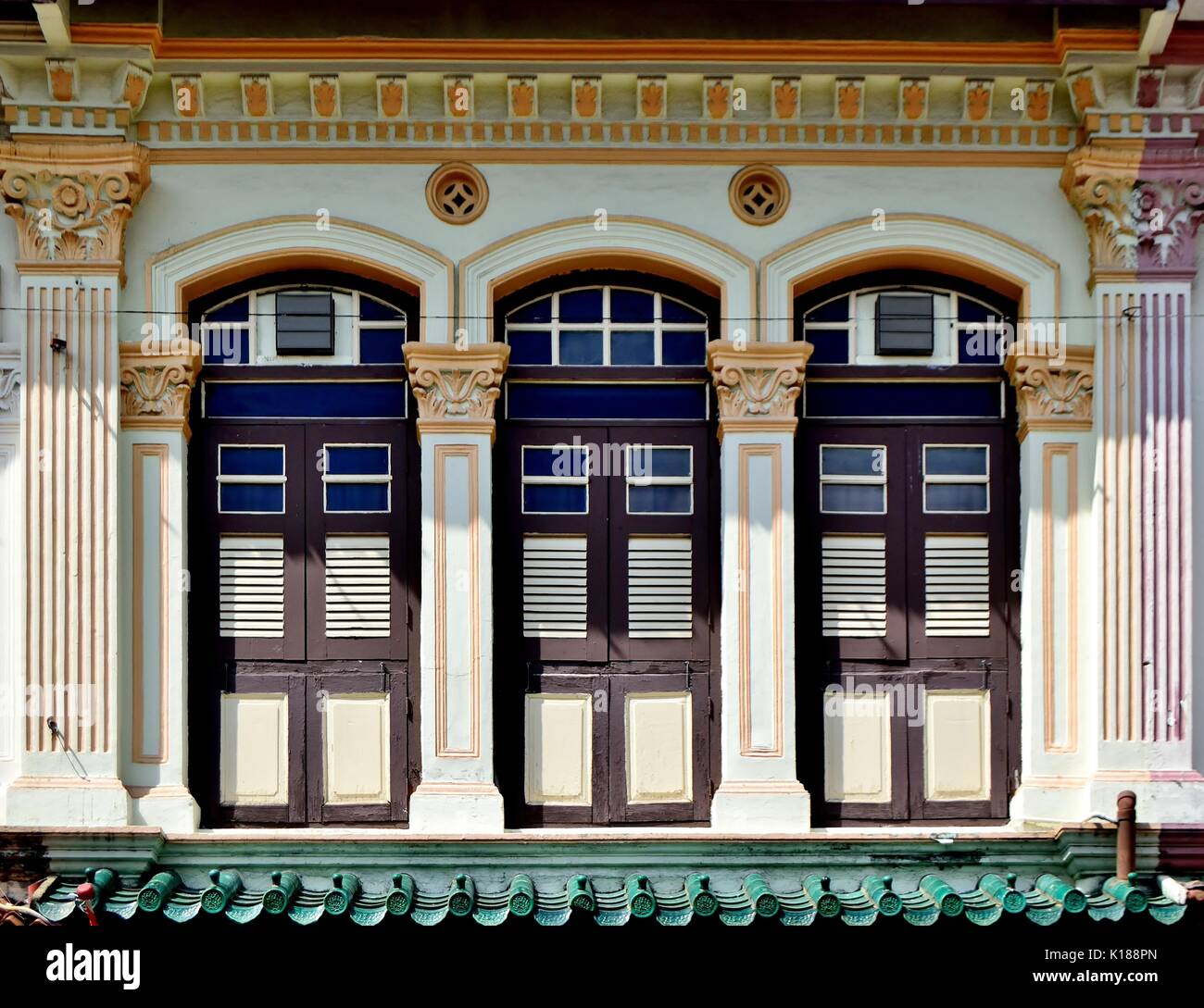Traditional shop house exterior with brown wooden louvered shutters and ...