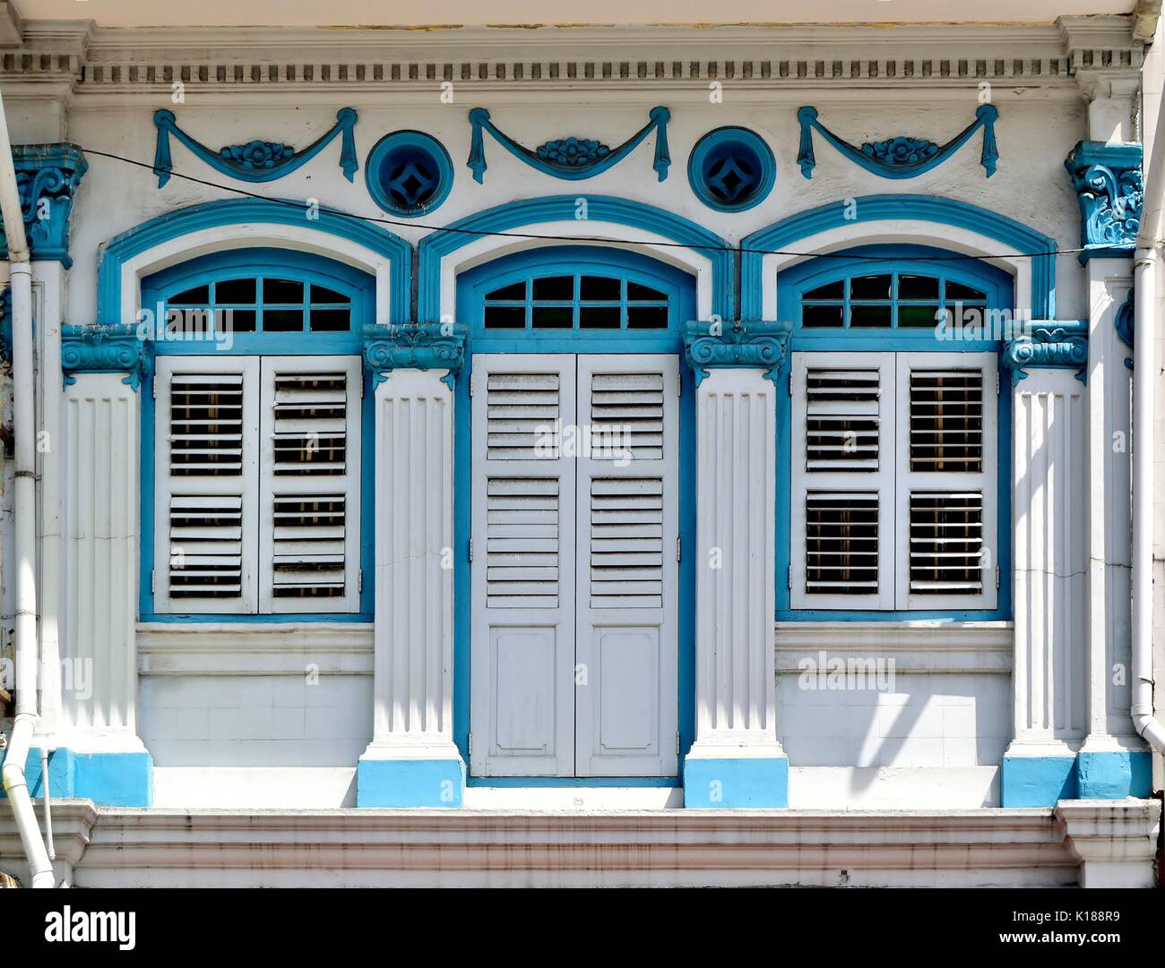 Traditional shop house exterior with white wooden louvered shutters ...