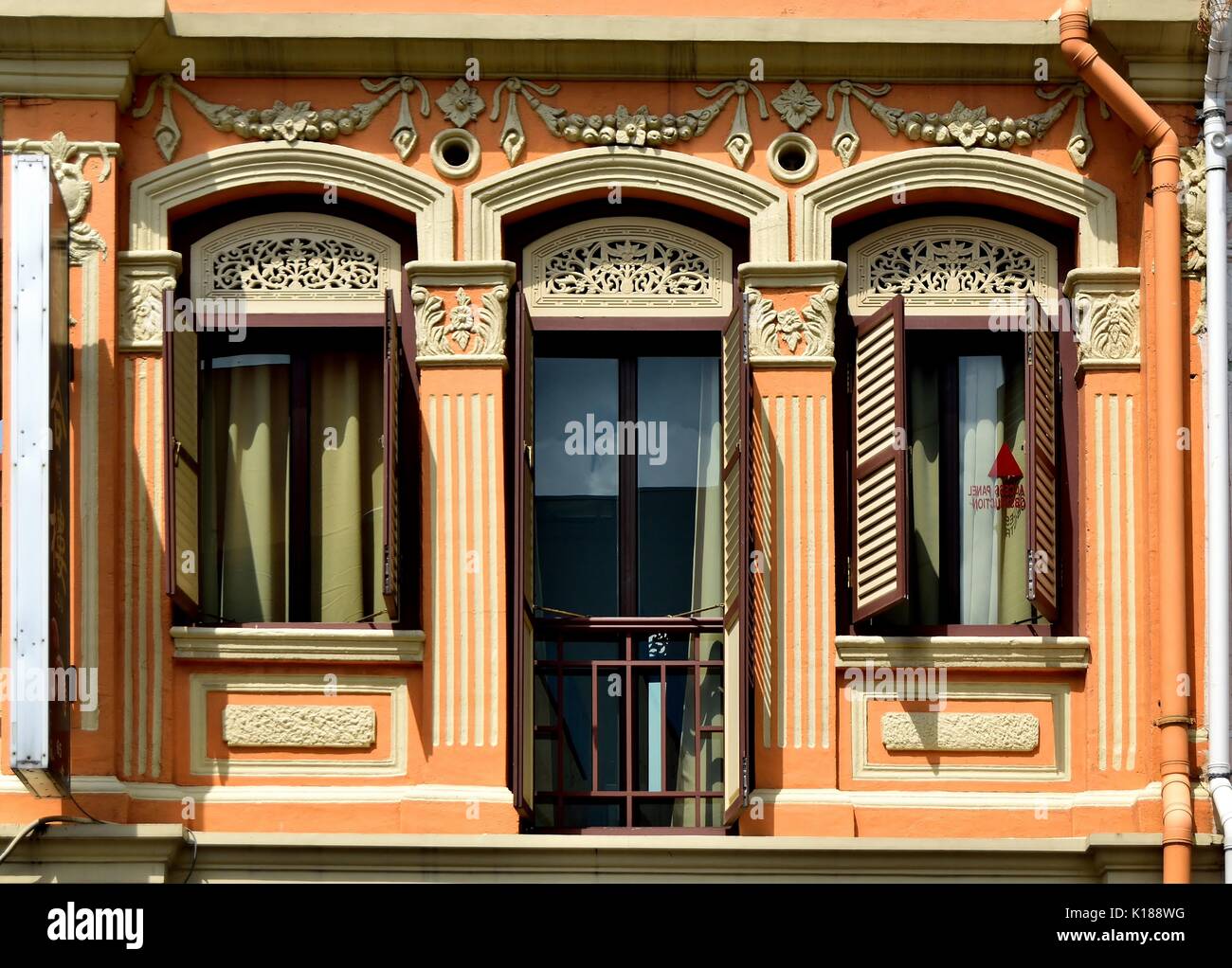 Traditional shop house exterior with wooden louvered shutters, peach ...