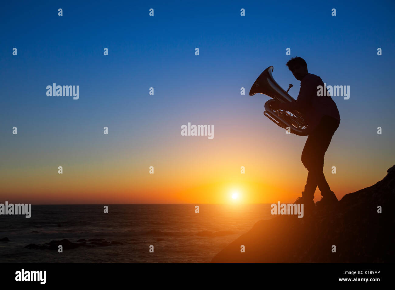 Silhouette of musician play Tuba on sea shore at amazing sunset Stock ...