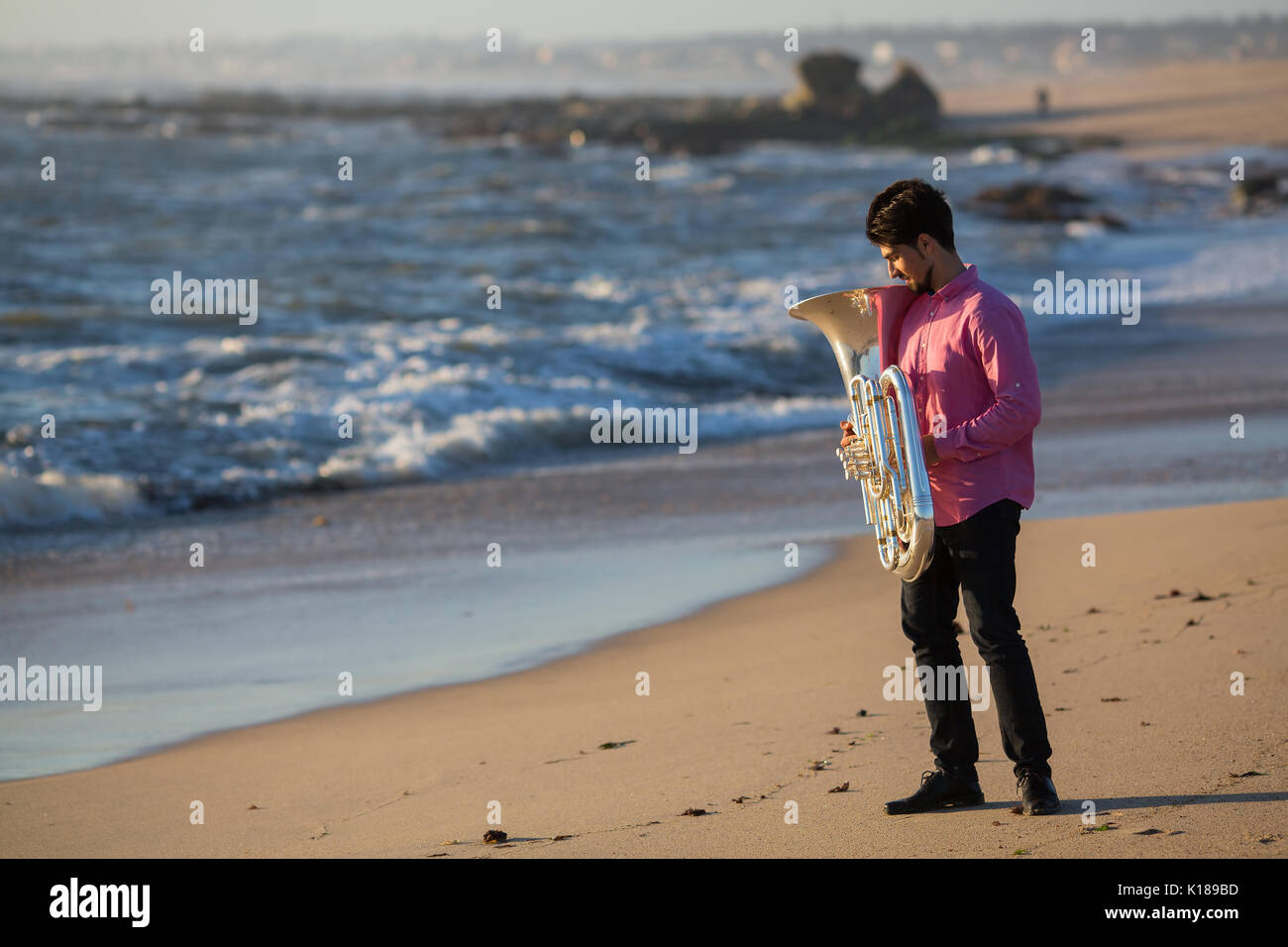 Musician with musical instrument Tuba on romantic sea shore Stock Photo ...