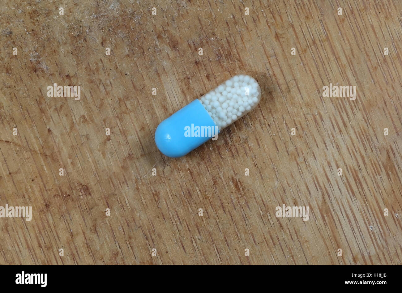 Blue pill capsule on wooden background Stock Photo - Alamy
