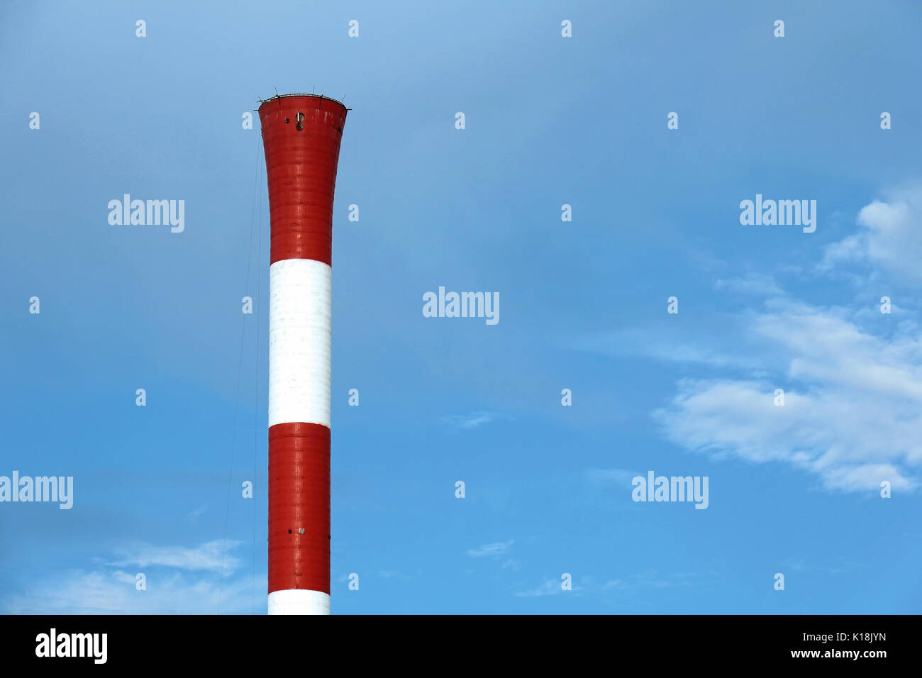Red and white industrial chimney on blue sky background Stock Photo - Alamy