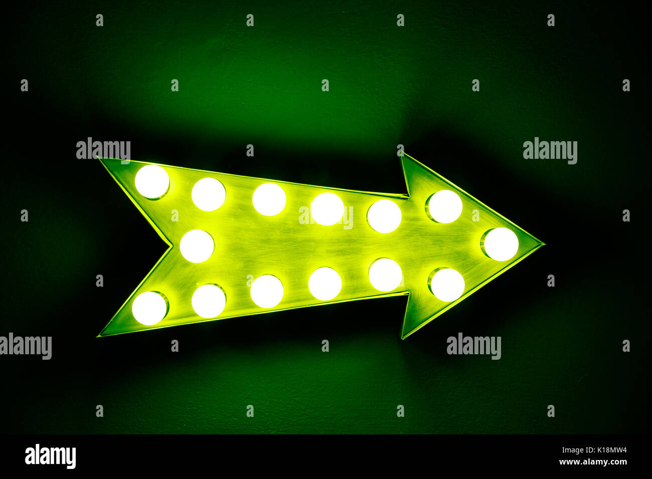 Green vintage bright and colorful illuminated display arrow sign with ...
