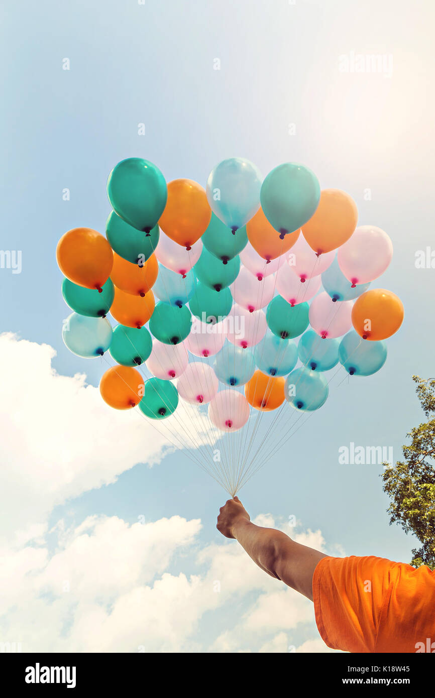 vintage of colorful balloon in hand on blue sky with sun haze Stock ...