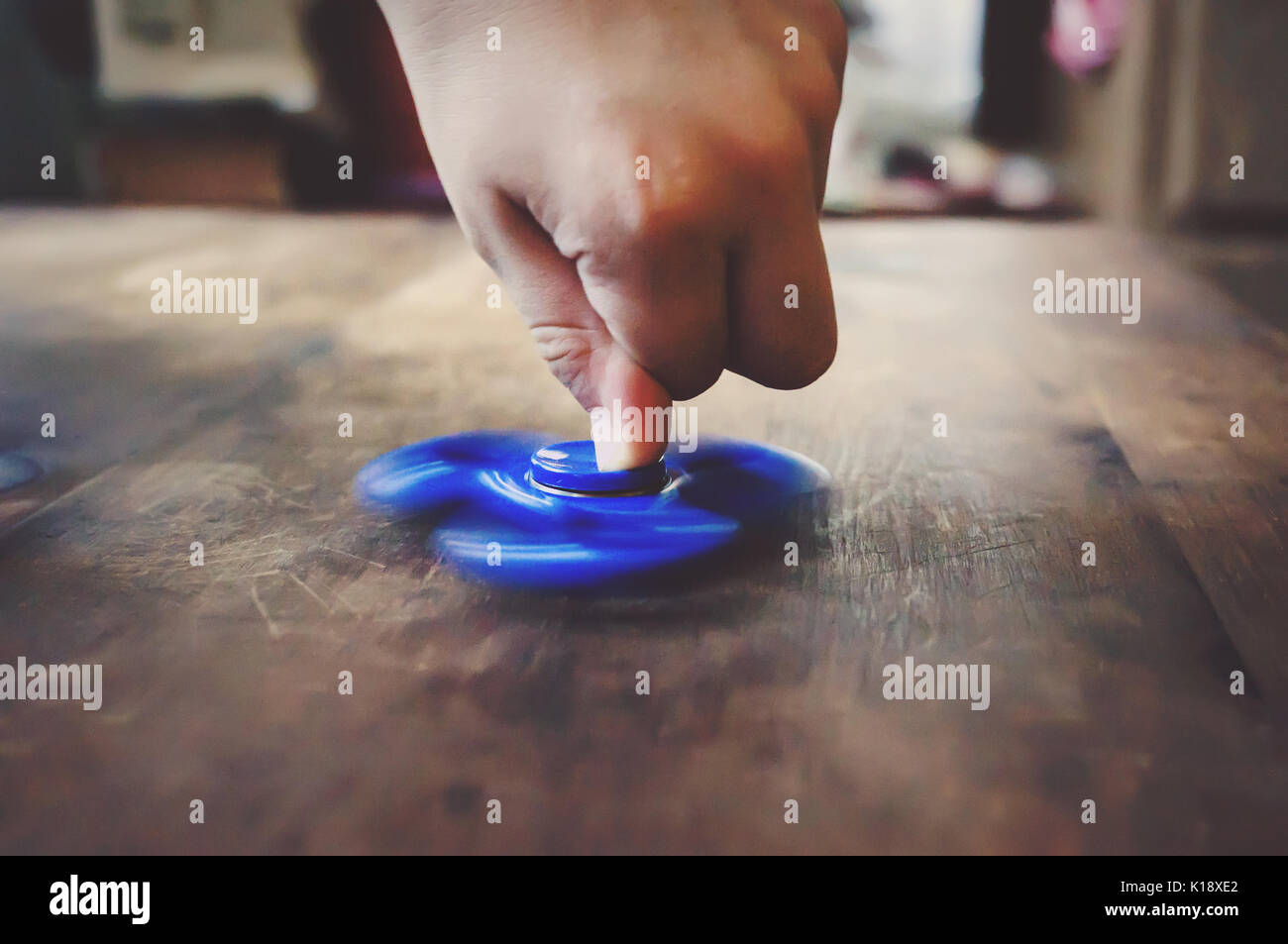 Blue Hand spinner, fidgeting hand toy rotating on child's finger. the ...