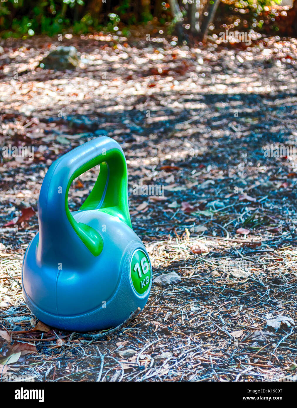 Closeup of a grey and green kettlebell in a garden Stock Photo - Alamy