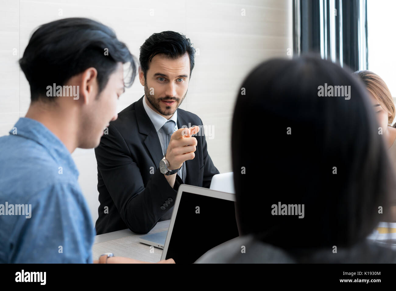 Young Businessman boss talking to employee, pointing to employee ...